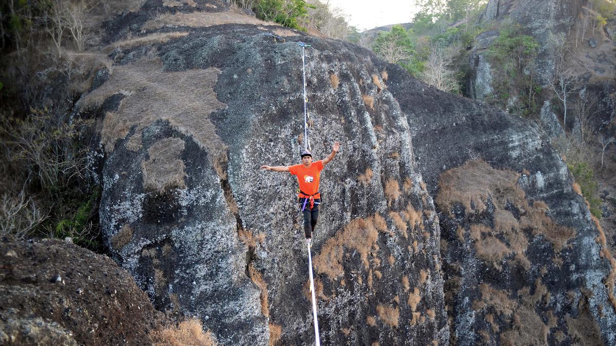 FOTO: Promosikan Pariwisata, Pemuda Ini Meniti Tali di Ketinggian 740 ...