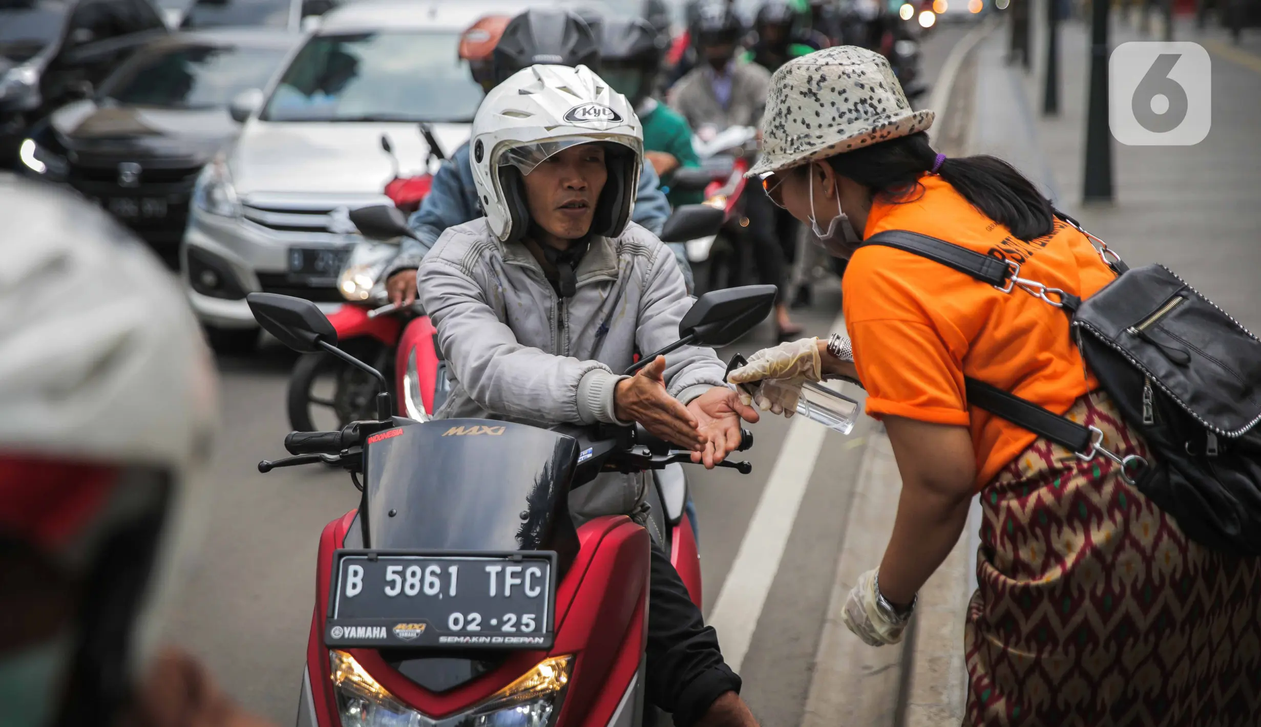 FOTO: Aksi Semprotkan Hand Sanitizer ke Pengguna Jalan - Foto Liputan6.com