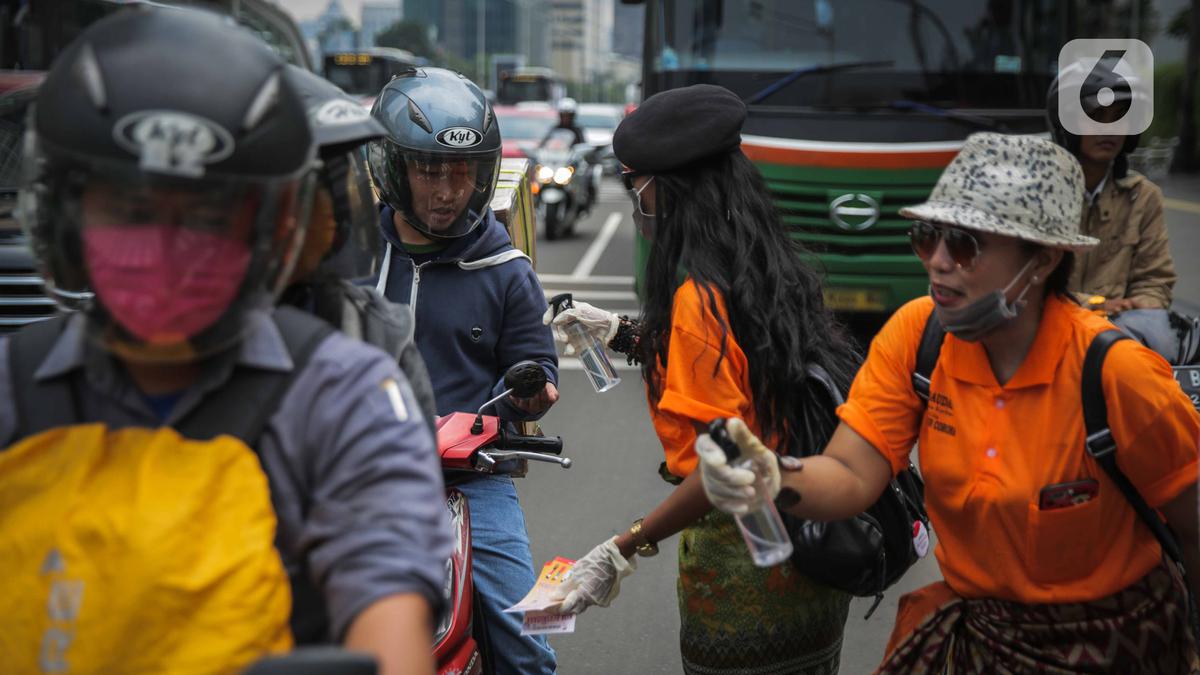 FOTO: Aksi Semprotkan Hand Sanitizer ke Pengguna Jalan - Foto Liputan6.com